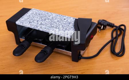Table-top grill involved in serving swiss dish of raclette Stock Photo ...