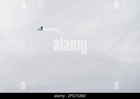 Single freeriding skier making fresh first tracks in recent powder snow ...