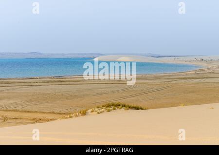 Sand dunes descending into the creek with limestone hills in the ...