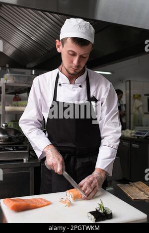 Japanese cuisine. Chef cuts rolls, hands close-up Stock Photo - Alamy