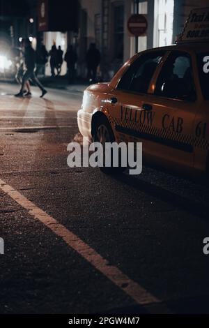 A cab in an urban area with the lit taxi sign on top of its roof Stock ...