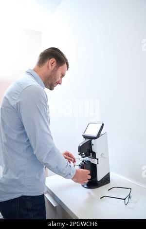 Optometrist manufacturing eyeglass lenses Stock Photo - Alamy