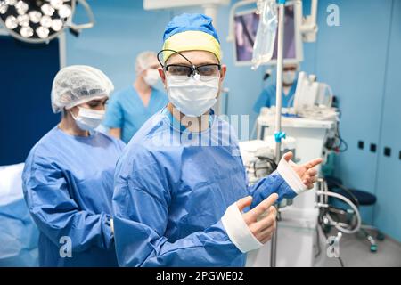 Nurse in preoperative room helps surgeon put on sterile gown Stock ...