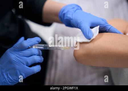 Medic doing injections in salon to young female Stock Photo - Alamy