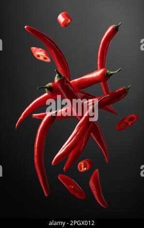 Ripe red chili peppers flying on white background Stock Photo - Alamy