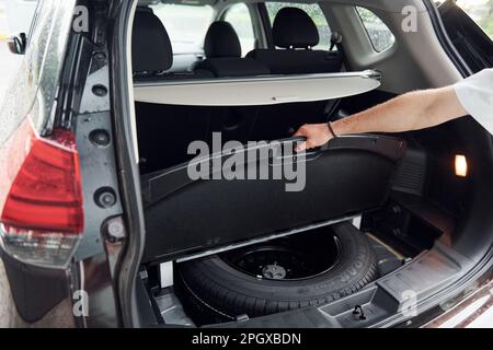 Woman's hands opening car trunk. Close up view. White modern automobile ...