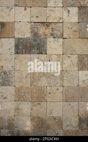 A background of a mosaic stone wall texture in the shades of brown ...