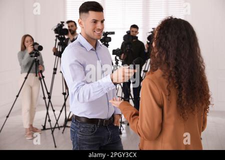 Professional journalist interviewing young African American woman ...