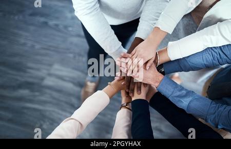 The secret is always teamwork. a group of businesspeople putting their ...