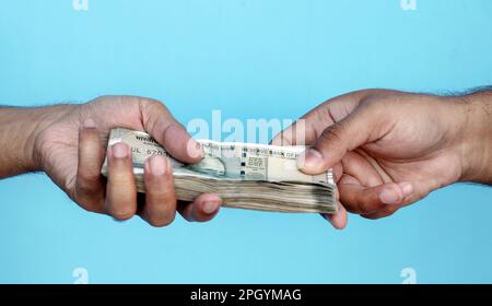 Man's Hand Giving Indian 500 Rupee Bank Notes. concept for earnings or ...