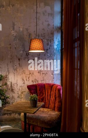 Stylish armchair with plaid and lamp near color wall Stock Photo - Alamy