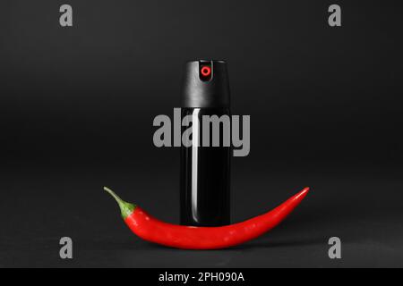 Bottle of gas pepper spray and fresh chili peppers on red background ...