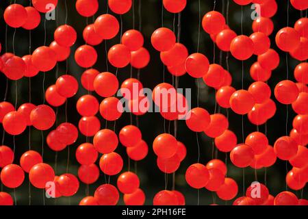 Red balls suspended on wire, outdoor art object symbolizing blood cells ...