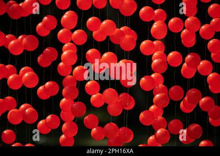 Red balls suspended on wire, outdoor art object symbolizing blood cells ...