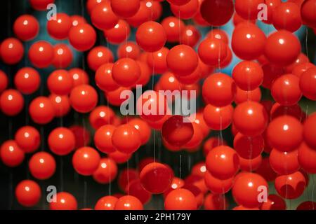 Red balls suspended on wire, outdoor art object symbolizing blood cells ...