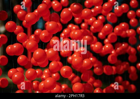 Red balls suspended on wire, outdoor art object symbolizing blood cells ...