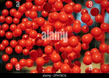 Red balls suspended on wire, outdoor art object symbolizing blood cells ...
