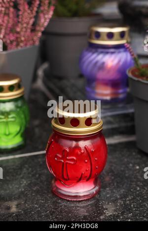 Different grave lanterns on granite tombstone outdoors. Funeral ceremony Stock Photo - Alamy