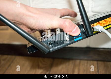 WiFi router, back of the router, hand holding the router with wires ...