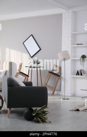Interior of messy living room with overturned furniture after ...