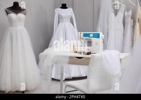 Dressmaking workshop interior with wedding dresses and equipment Stock ...