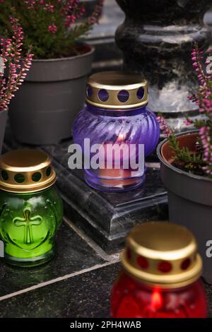 Different grave lanterns on granite tombstone outdoors. Funeral ceremony Stock Photo - Alamy