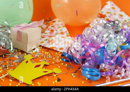 Colorful serpentine streamers and other party accessories on orange ...