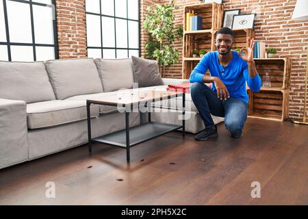 African american man at home with cockroach infestation celebrating ...