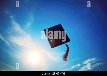 Graduation cap thrown into the blue sky. Graduation from an educational ...