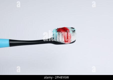 Toothbrush with paste and blood on white background. Gum inflammation ...