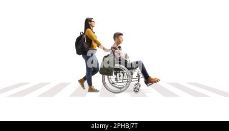 Female student pushing a friend in a wheelchair at a pedestrian ...