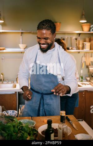 Male chef wearing apron and preparing food at commercial kitchen in ...