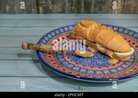 Bun with salami egg and mustard dressing on arabic dish and wooden old ...