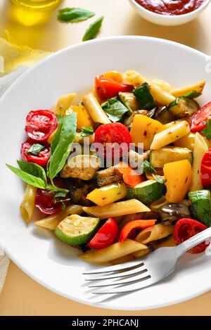 Ratatouille pasta salad on plate over light background. Top view, flat ...
