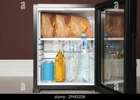 Mini bar filled with food and drinks near white wall indoors Stock ...