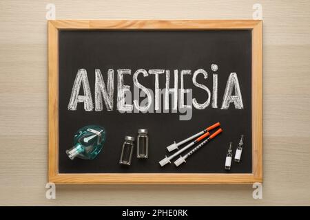 Blackboard with word Anesthesia, vials, mask and syringes on wooden ...
