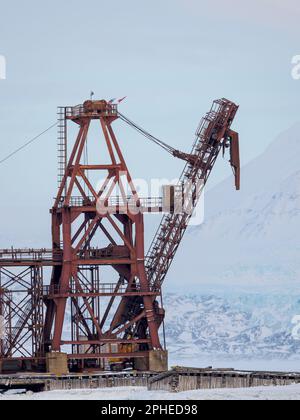Harbour with loading crane, glacier Nordensjoeldbreen in the background ...