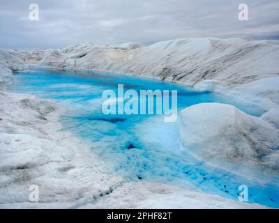 Drainage system on the surface of the ice sheet. The brown sediment on ...