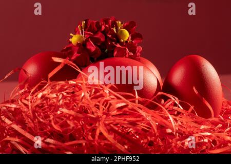 Colored eggs symbolize Easter in shades of red on straw Stock Photo - Alamy