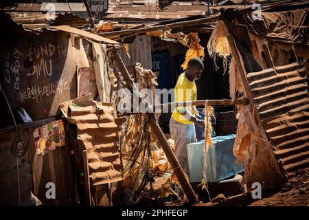 A man works inside a shack of Kibera slum, Nairobi, Kenya. Kibera is ...