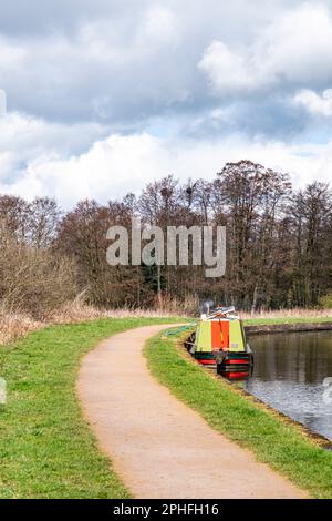 A narrowboat moored on the tow path with a blue bridge over The Regents ...