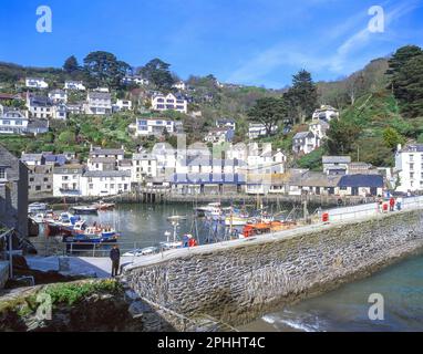 Tourist on harbour wall Polperro Harbour Cornwall England Summer 2005 ...