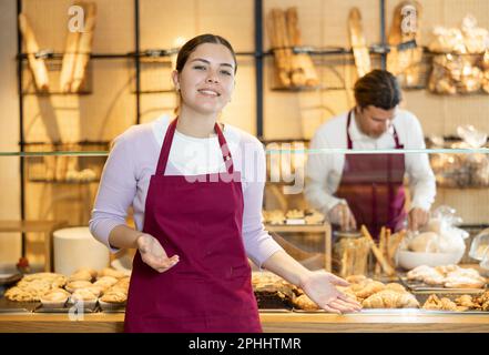 Cheerful female baker welcoming everyone into her bakery Stock Photo ...