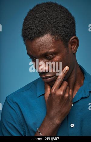 Portrait of sad man against blue background Stock Photo - Alamy