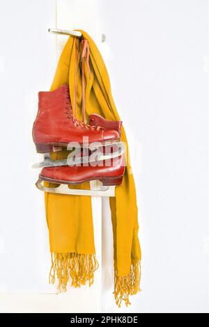 Girl skates and red scarf hanging on the door Stock Photo - Alamy