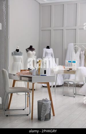 Dressmaking workshop interior with wedding dresses, female clothes and ...