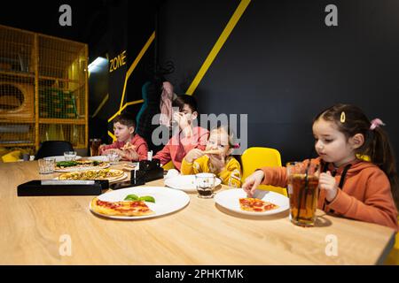 Four kids eating italian pizza in pizzeria. Children eat at cafe Stock ...