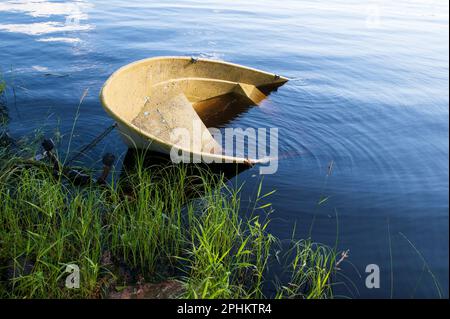 Sunken small motor boat on the shore Stock Photo - Alamy