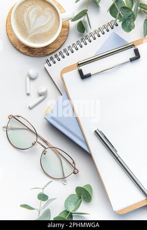 Computer keyboard with cup of coffee and eucalyptus branch on pink ...