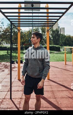 Young man bodybuilder having break during his workout in a modern ...